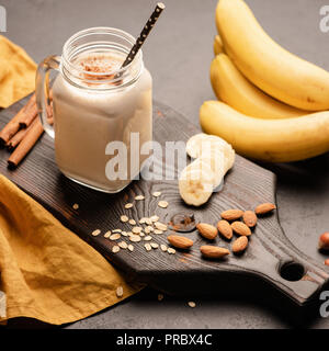 Protein milkshake or smoothie with banana and oats on concrete table ...