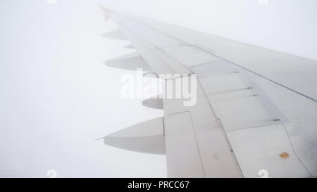 Aircraft in heavy fog with wing condensation and aircraft vortex ...