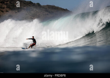 Surfer riding a large wave at Scar reef in West Sumbawa, Indonesia ...