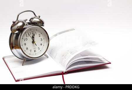Calendar with alarm clock, notebook, paper pins and pen on beige ...