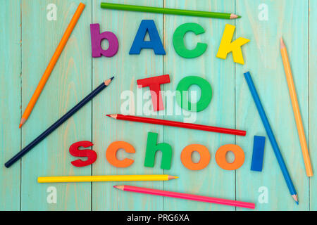 Sentence BACK TO SCHOOL with a colorful pencils on wood background ...