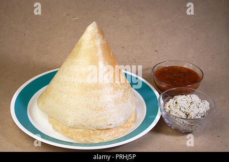 Dosa in the shape of a cone on a plate against a white background Stock ...