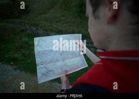 Man reading a map whilst hiking in the Peak District. Map-reading ...