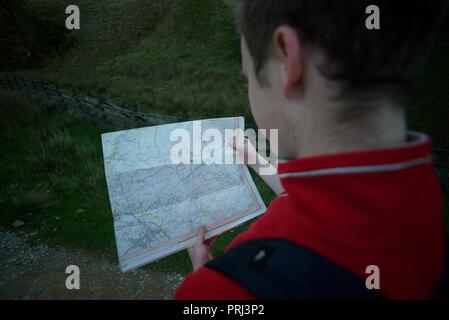 Man reading a map whilst hiking in the Peak District. Map-reading ...