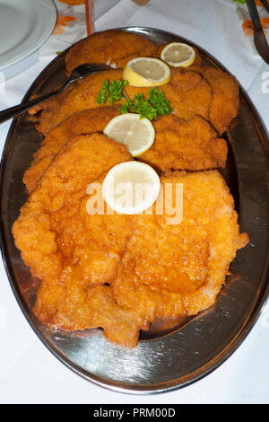 Wiener Schnitzel vom Kalb mit Zitronen Scheiben auf einer Platte Stock ...
