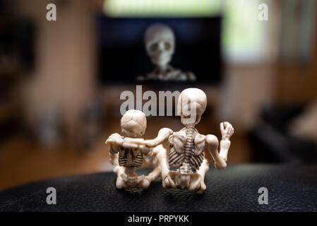 Skeleton Parent and child watching TV together Stock Photo - Alamy