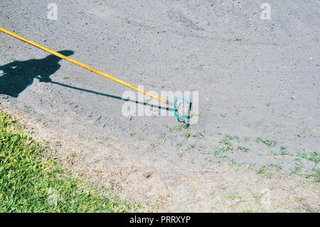 Woman raking grass using rake. Person taking care of garden house yard ...