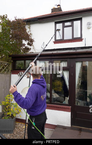 Window Cleaner using the ‘reach and wash’ system (water-fed pole and ...