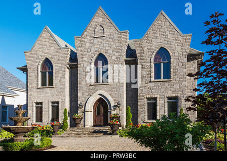 Exterior of a gothic stone house with arched leaded glass windows and ...