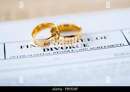 Divorce decree and two broken wedding rings. Divorce and separation ...