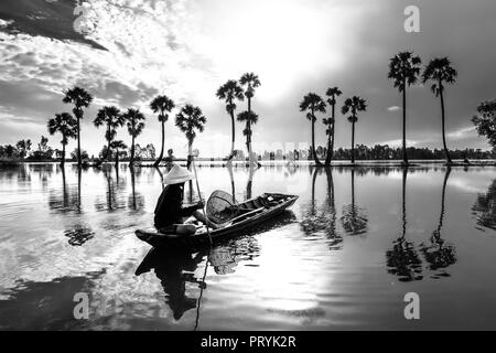 Unidentified fishers catch fish with bamboo tools in a lake when ...