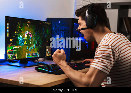 Portrait of caucasian gamer guy screaming and rejoicing while playing ...