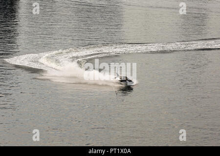 London's Royal Docks. UK 5 Oct 2018 - Man riding a whale shaped jet-ski ...