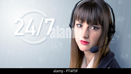 Young female telemarketer with a 24 7 sign next to her Stock Photo - Alamy