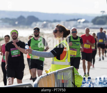 Runners passing a refreshment drink station while running in "Pocari ...