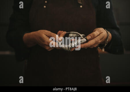 Closeup of female jeweler holding ring size gauge to check female ...