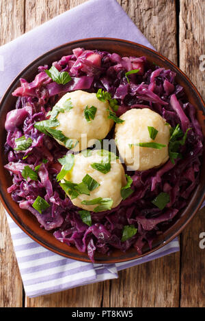 Delicious potato dumplings with stewed red cabbage close-up on a plate ...
