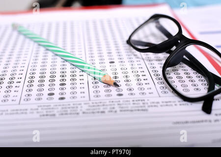 Picture of OMR sheet, pencil and glasses. Isolated on wooden background ...