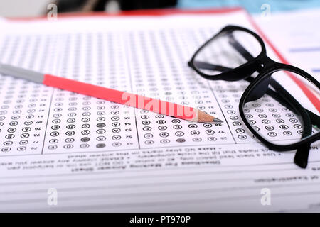 Picture of OMR sheet, pencil and glasses. Isolated on wooden background ...
