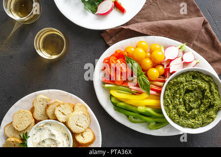 Various vegetable snacks for wine on gray concrete background top view ...