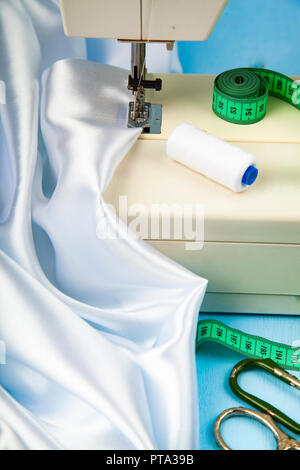 Sewing machine and white satin fabric close-up Stock Photo - Alamy