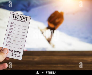 Bookmaker ticket on the background of a TV on which show skating sports ...