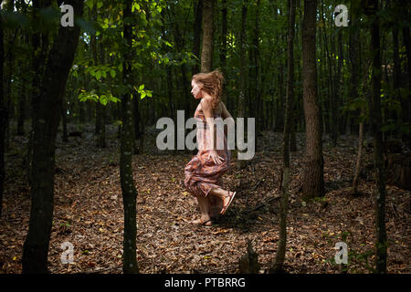 Scared woman running through the forest Stock Photo - Alamy