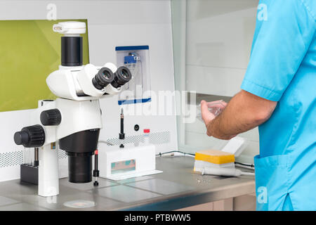 Embryologist or lab technician adjusting needle to fertilize a human ...