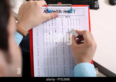 Erasing answer with pencil on Test score sheet with answers.Copy space ...