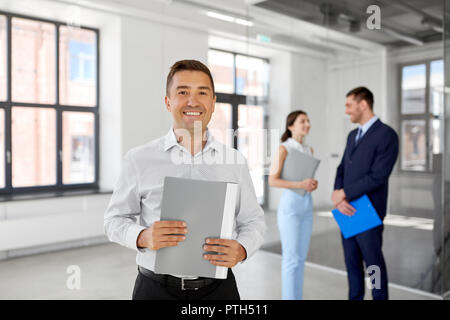 realtor with folder and customers at new office Stock Photo - Alamy