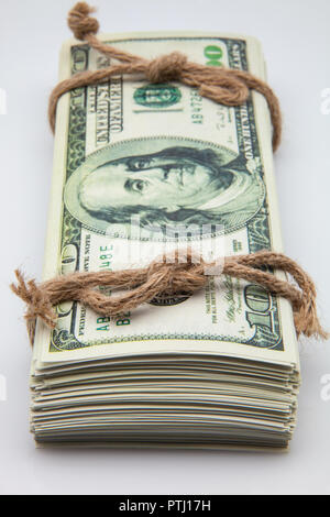 Rope tied roll of one hundred dollar bills isolated on white background ...