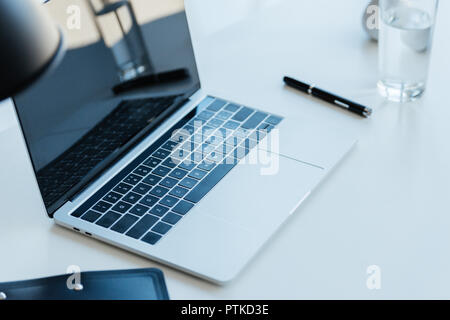 Modern laptop with blank screen at workplace in room Stock Photo - Alamy