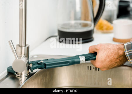 Plumber repairing tap at kitchen Stock Photo - Alamy