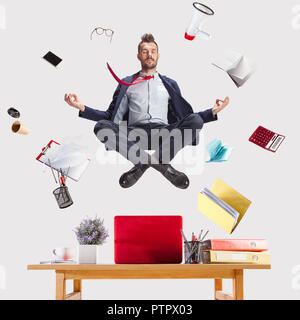 Office worker doing lotus pose on table in office Stock Photo - Alamy