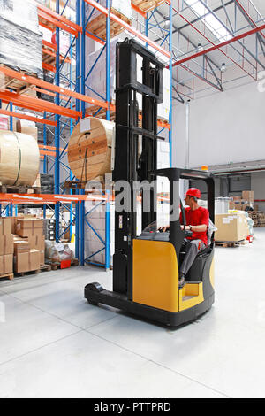Forklift loading pallet with roll in distribution warehouse Stock Photo ...