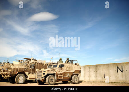 Desert camouflage armoured vehicles at base behind concrete walls Stock ...
