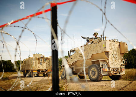 Desert camouflage armoured vehicles at base behind concrete walls Stock ...