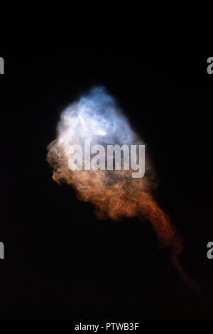 A SpaceX Falcon 9 rocket exhaust plume changes color at altitude as the ...