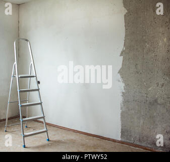 Stepladder on a gray wall background. Repair in the house or office ...