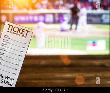 Bookmaker ticket on the background of a TV on which show skating sports ...