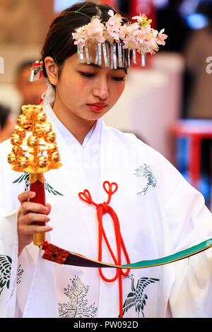 Miko shrine maiden performs ritual blessing and purification of new car ...