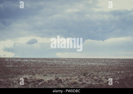 ploughed field and scary dark blue sky landscape Stock Photo - Alamy