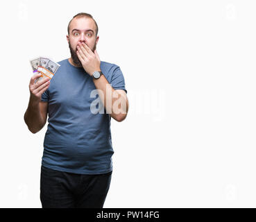 Surprised man holding money, looking amazed at camera, touching chest ...