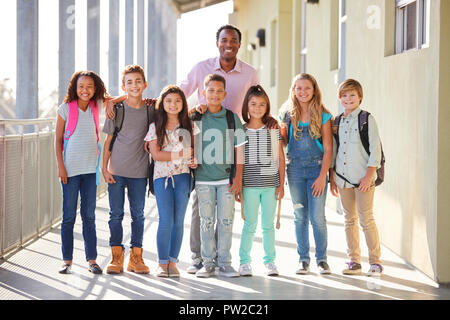 Primary school students waiting in line outside their classroom. Group ...