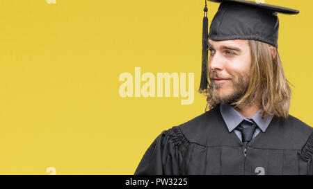 Young handsome graduated man with long hair over isolated background ...