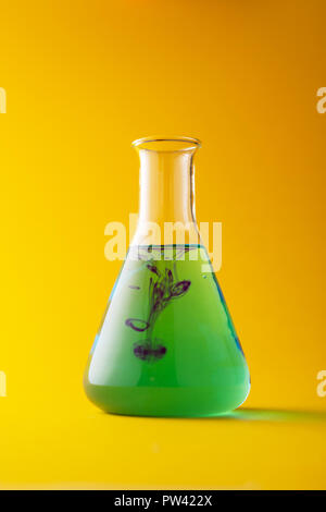 Over a blue background, erlenmeyer flask, a tube with spiral pipe ...
