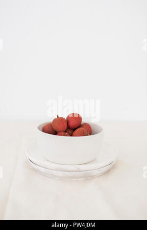 A high angle shot of a bowl of juicy oranges and a halved orange in a ...