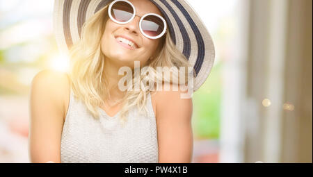 young blonde woman choose straw hat in shop Stock Photo - Alamy