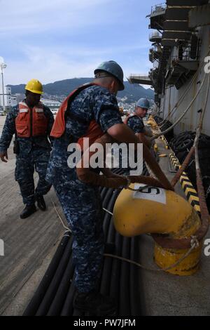 US Navy Four line handlers heave in one of the mooring lines Stock ...