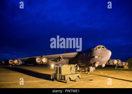 A U.S. B-52 Bomber sits on a flightline with munitions loaded on a ...